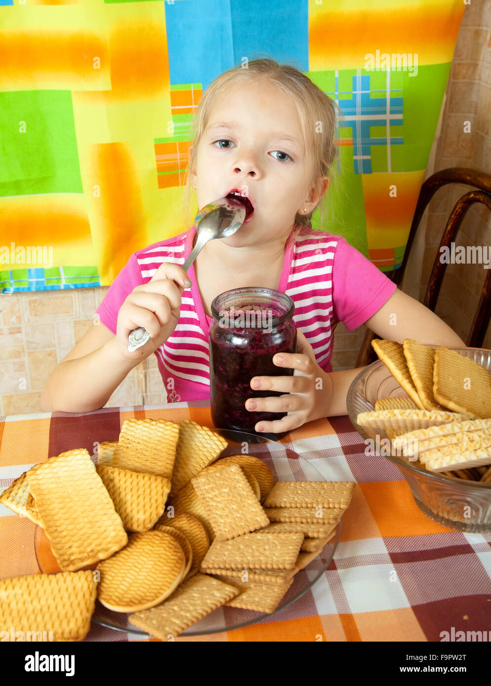 Little girl eating jam from jar at kitchen Stock Photo - Alamy