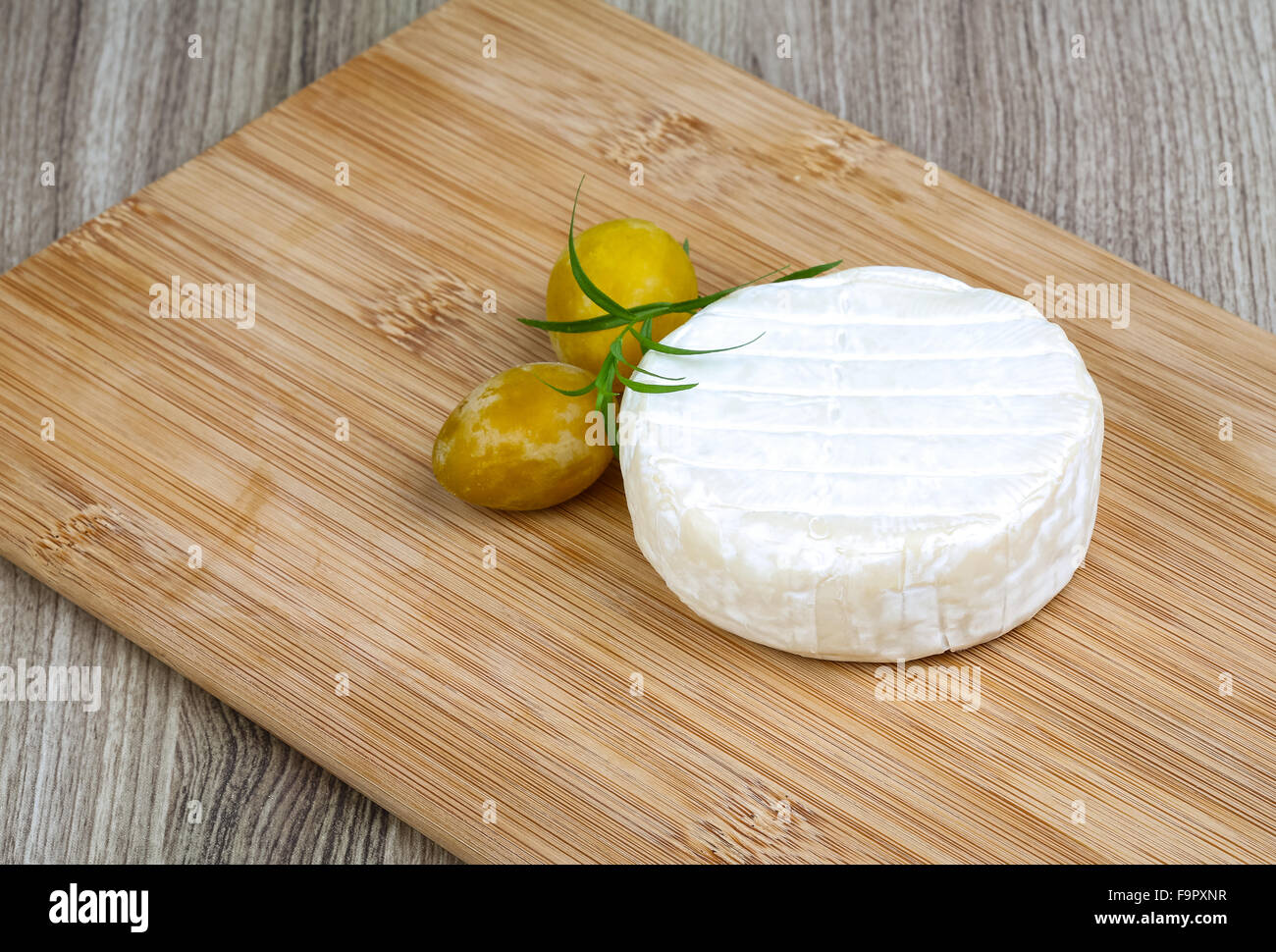 Round Brie cheese with yellow plums and estragon Stock Photo - Alamy