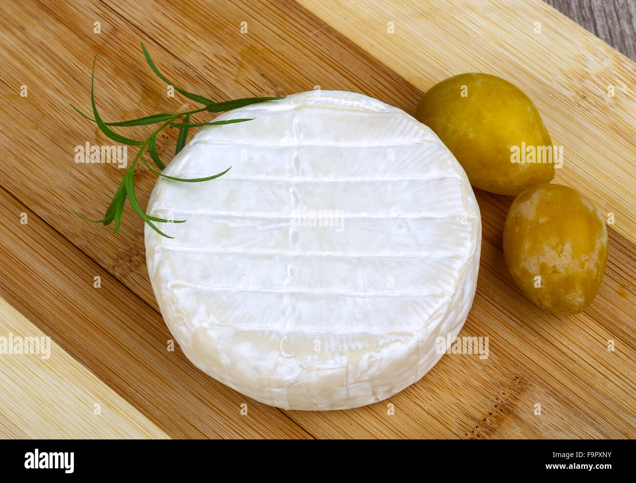 Round Brie cheese with yellow plums and estragon Stock Photo - Alamy
