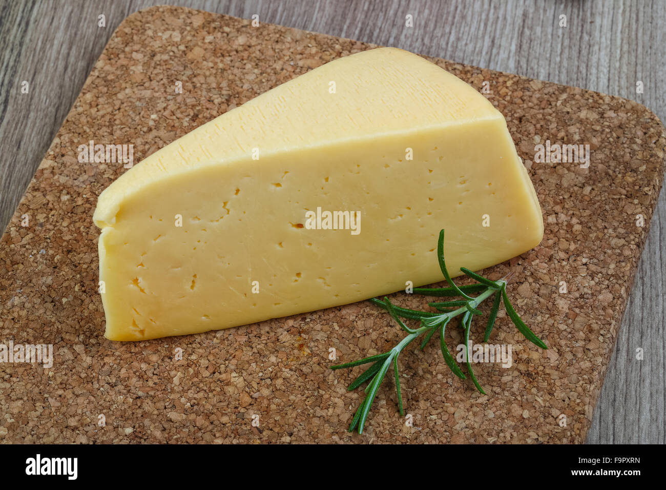 Yellow cheese triangle with rosemary herbs on the wood background Stock ...