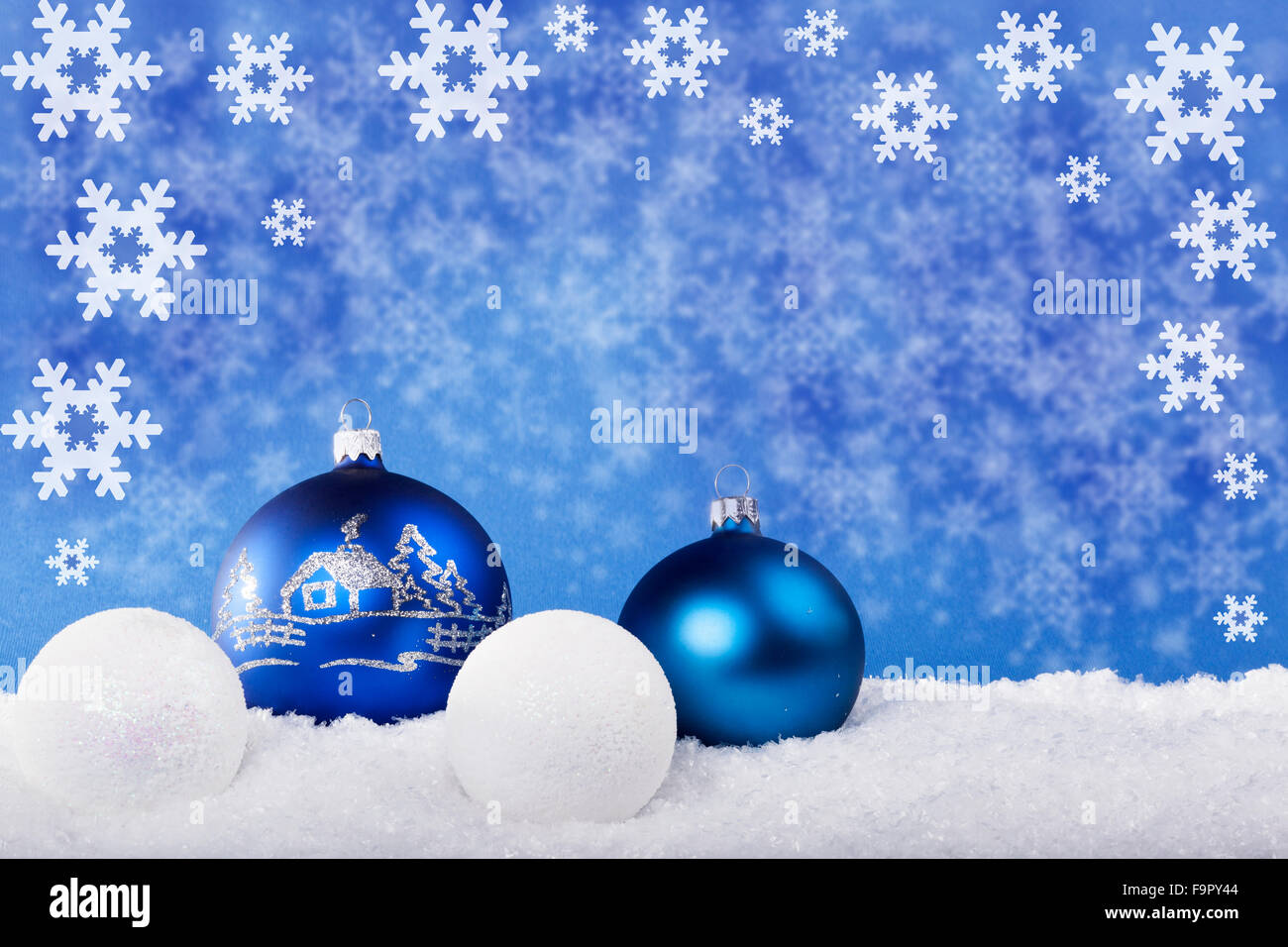Blue Christmas balls in the snow Stock Photo - Alamy