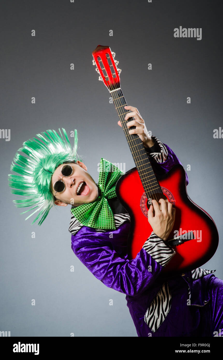 Funny man playing guitar in musical concept Stock Photo - Alamy