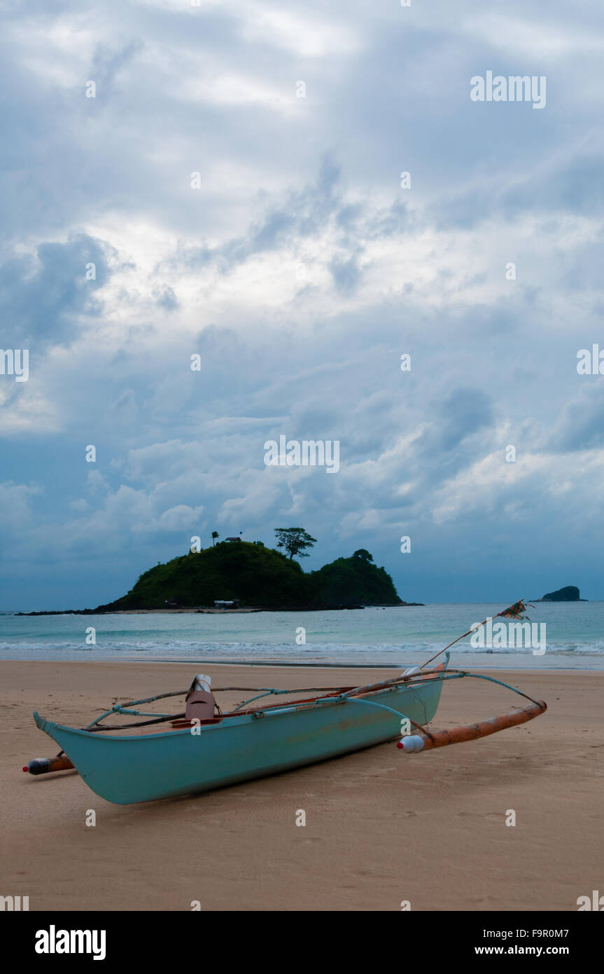 Blue Boat laying on the sand beach in front of ocean and island Stock ...