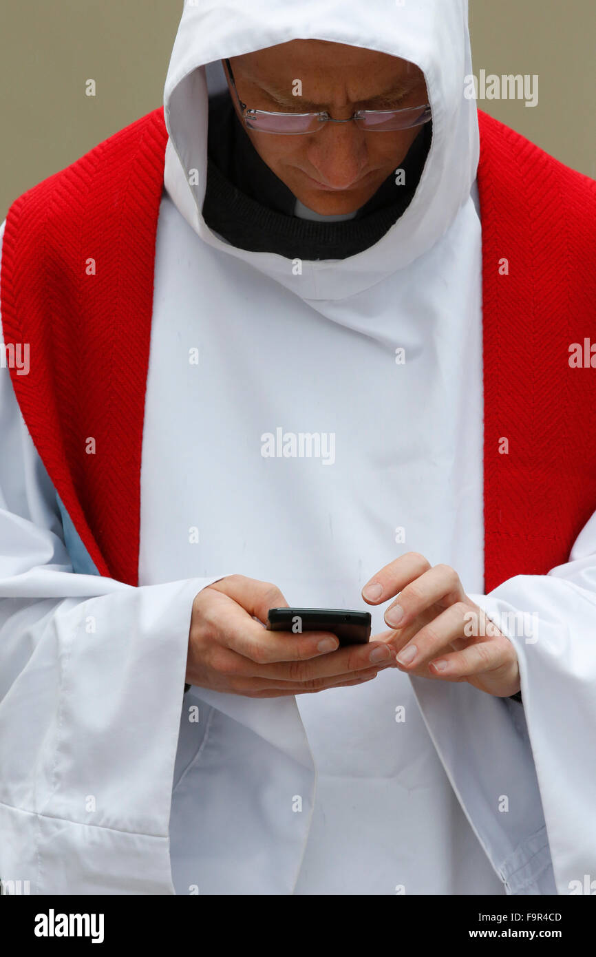 Catholic priest using a cell phone Stock Photo - Alamy