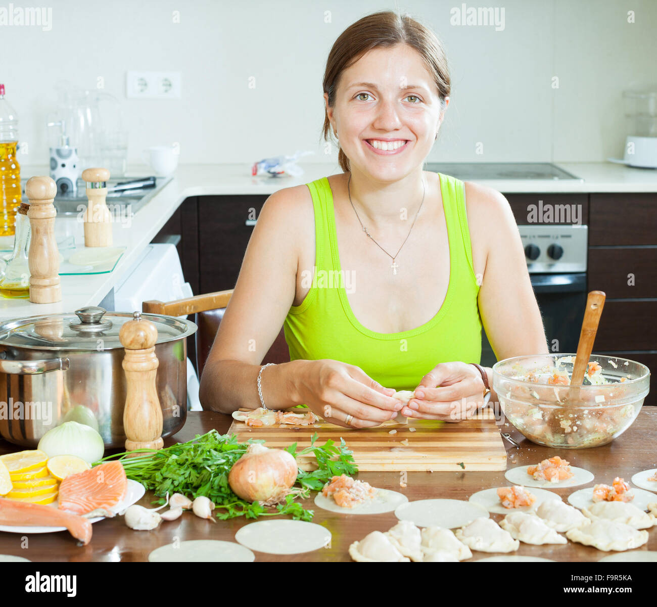Housewife makes salmon dumplings (pelmeni) on the light inside the ...