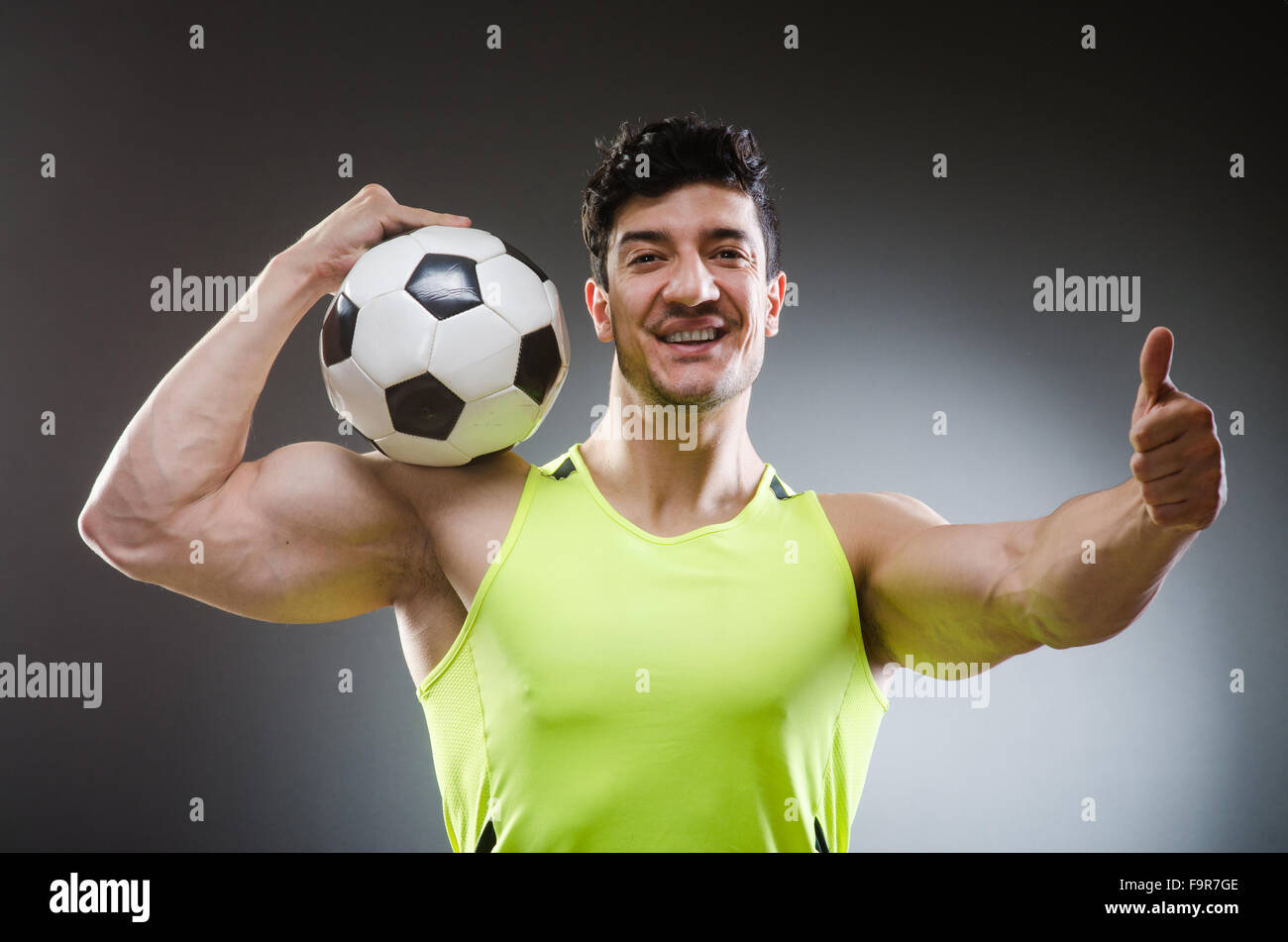 Muscular man with football ball Stock Photo - Alamy