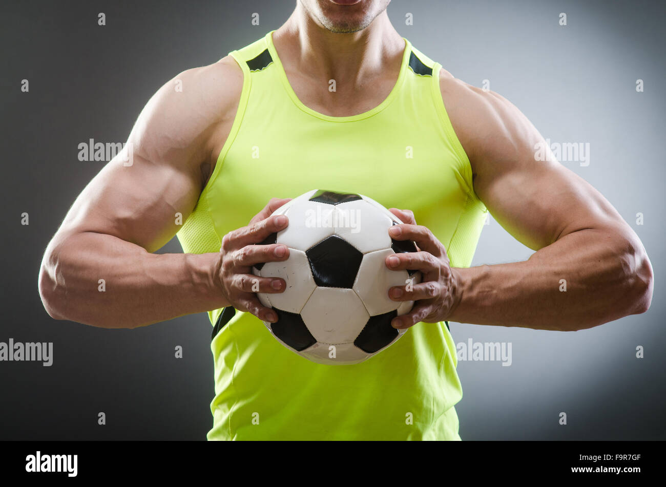 Muscular man with football ball Stock Photo - Alamy