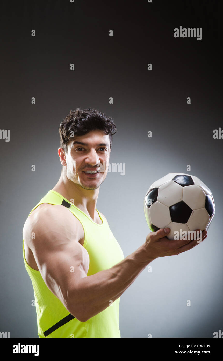 Muscular man with football ball Stock Photo - Alamy