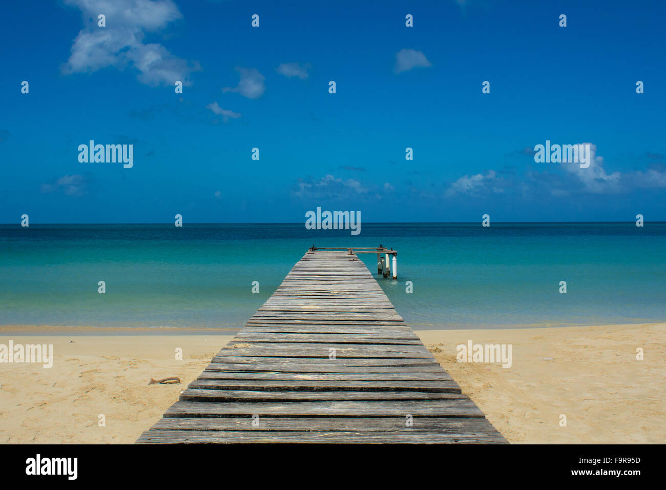 Small pier on a beach in caribbean tropical island Stock Photo - Alamy