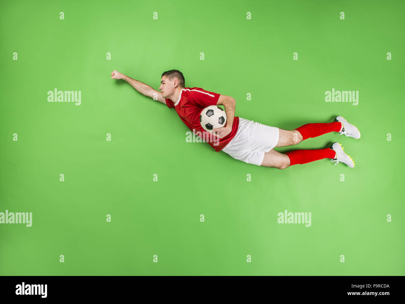 Flying football player in superman pose. Studio shot on a green ...