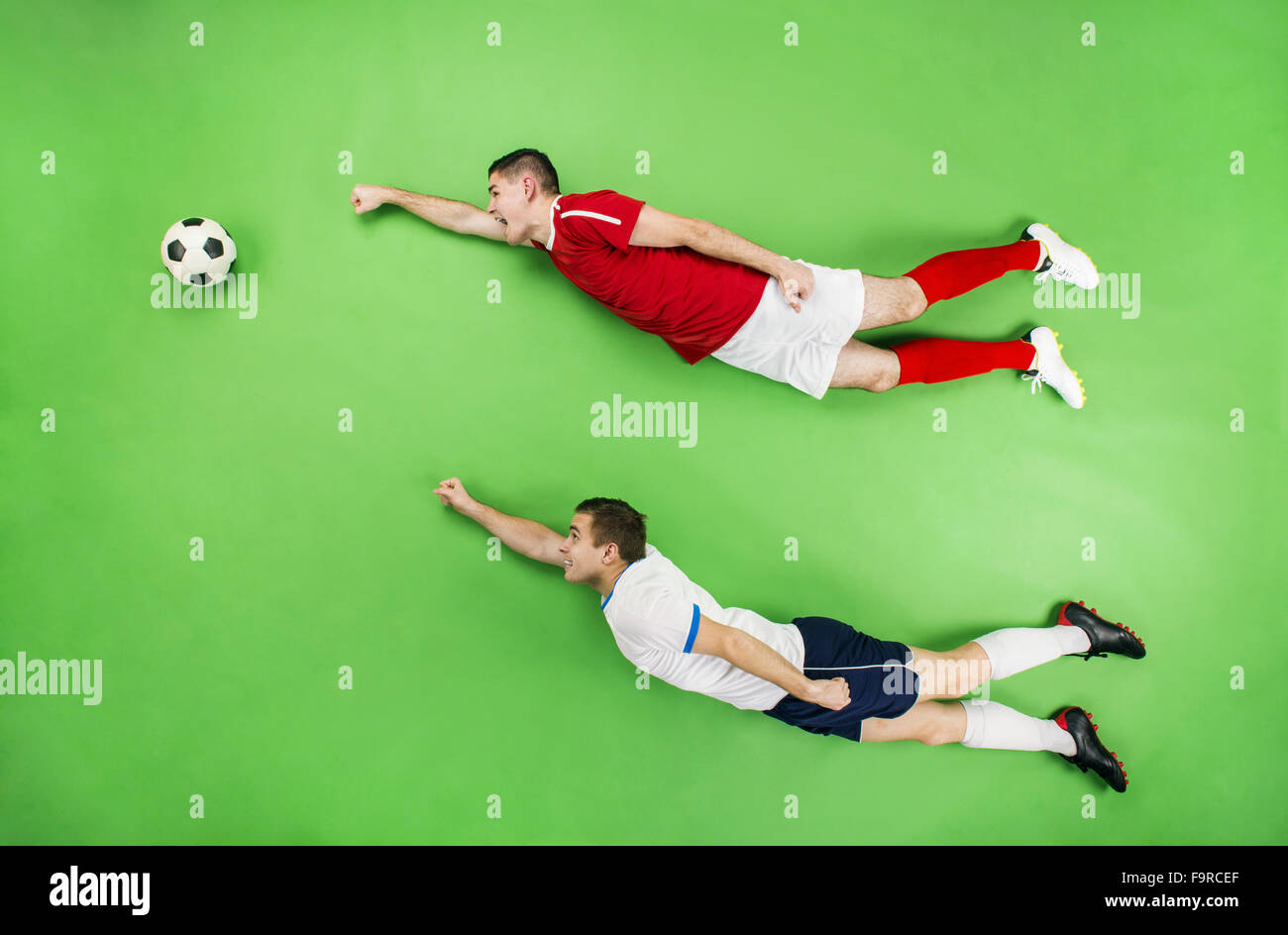 Two football players in a superman pose. Studio shot on a green ...