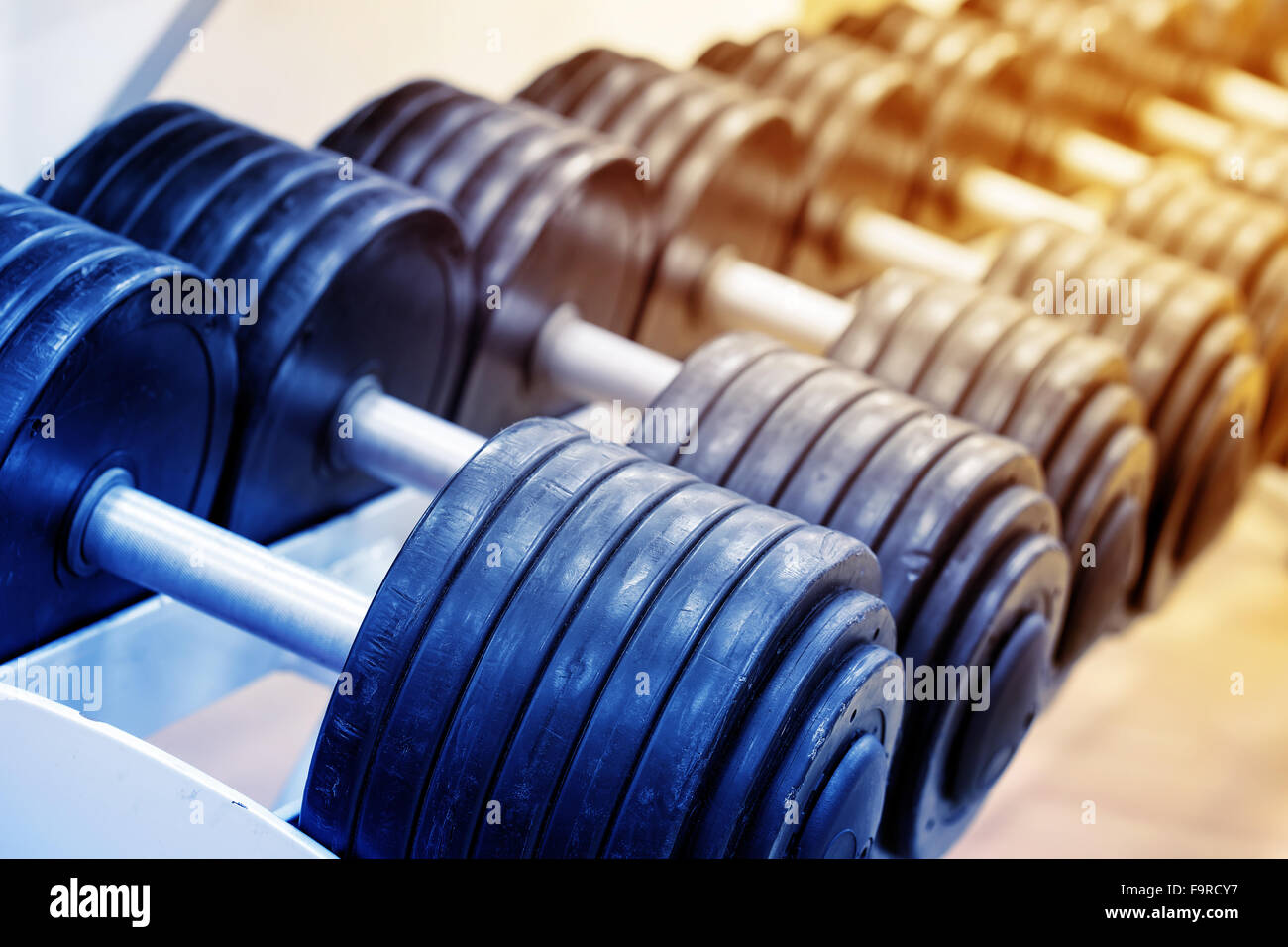 Number of heavy dumbbells on rack with ablurred background Stock Photo ...