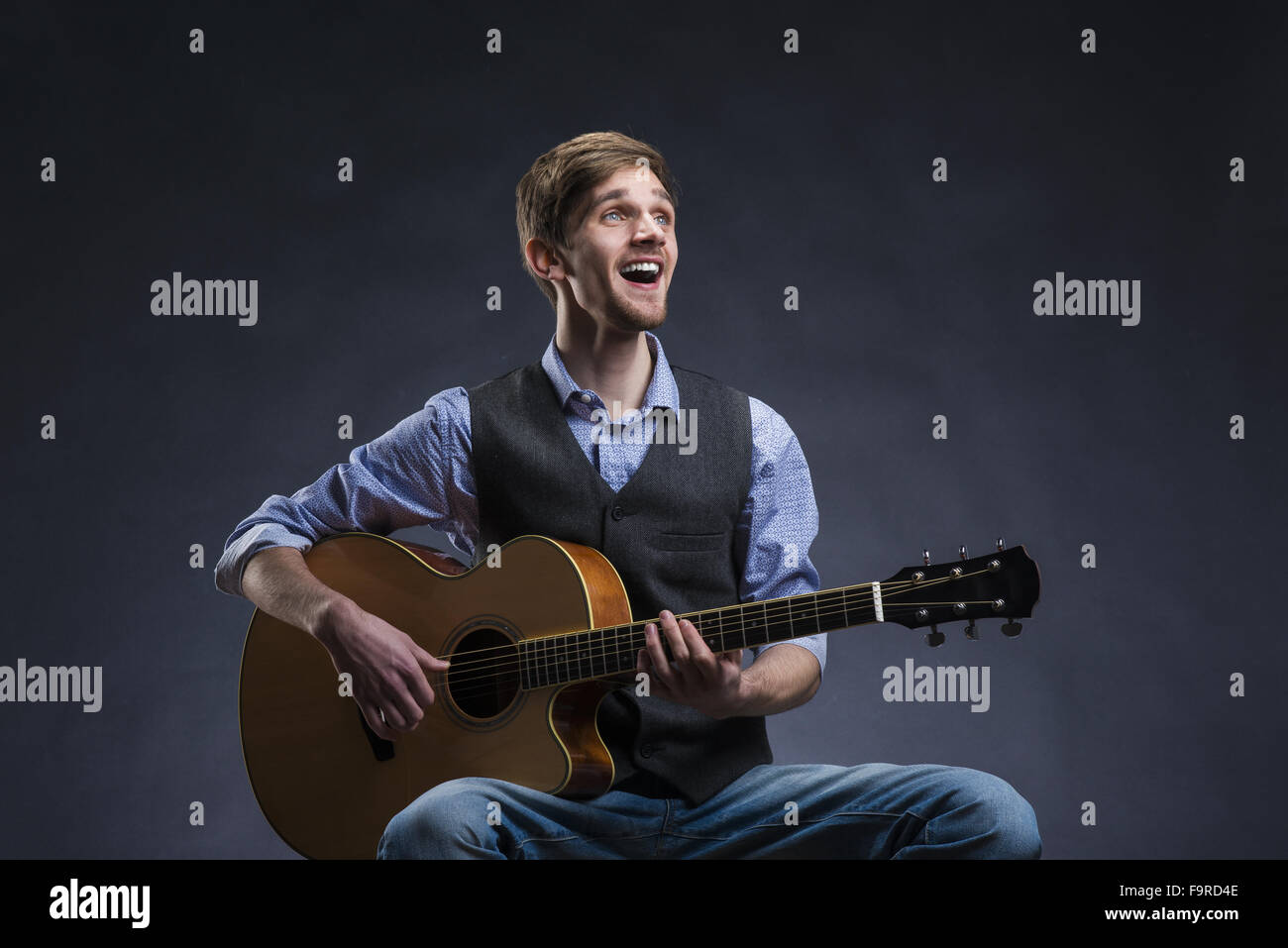 Young handsome guitar player. Studio shot on black background Stock ...