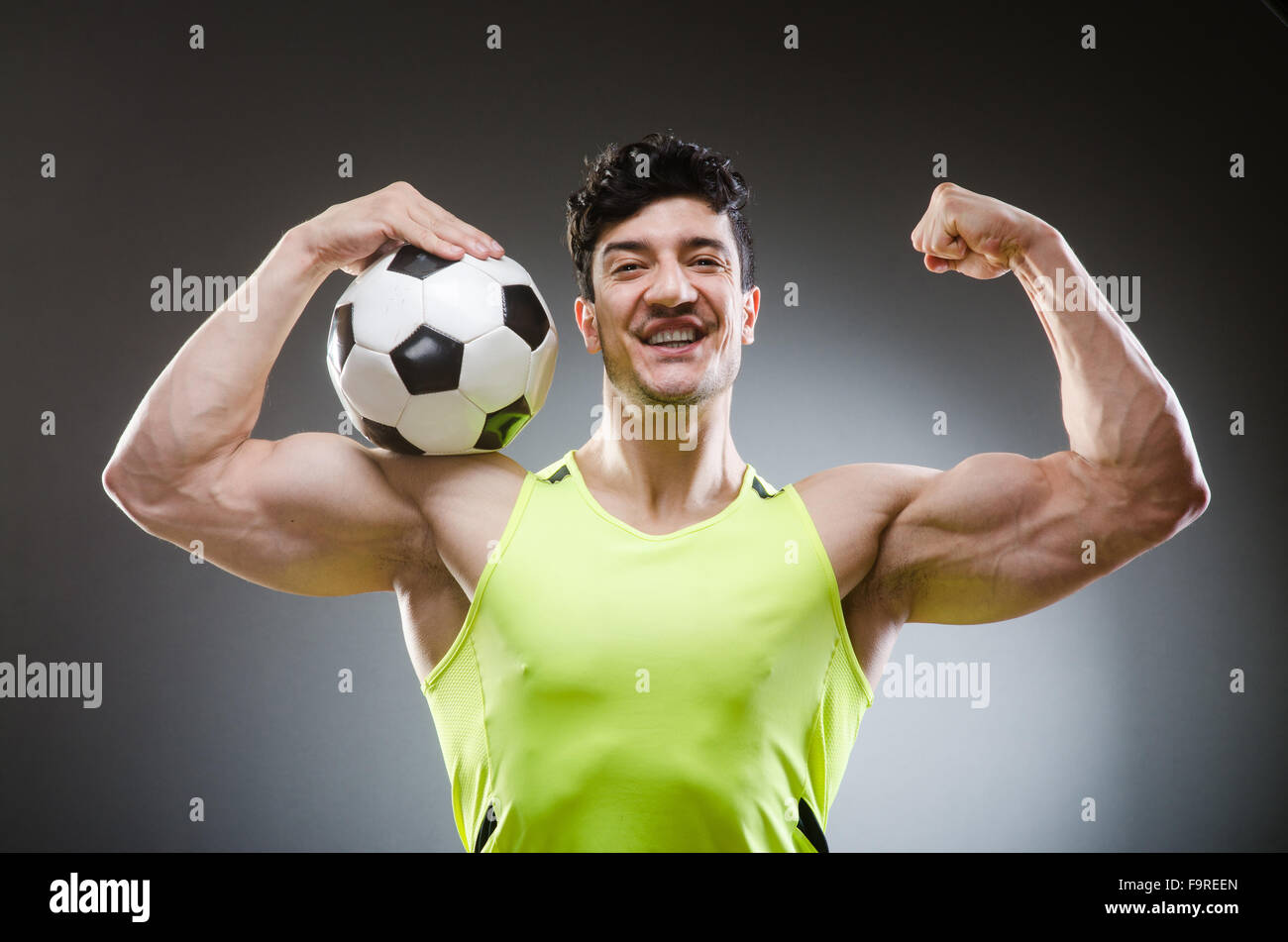Muscular man with football ball Stock Photo - Alamy