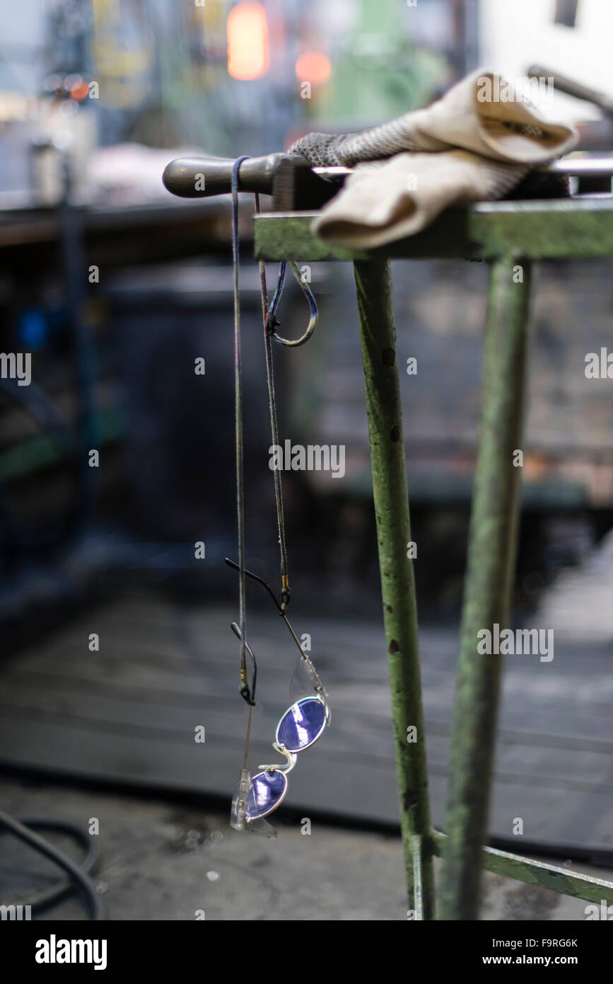 Protective gloves and goggles on a workbench at a glass blowing ...