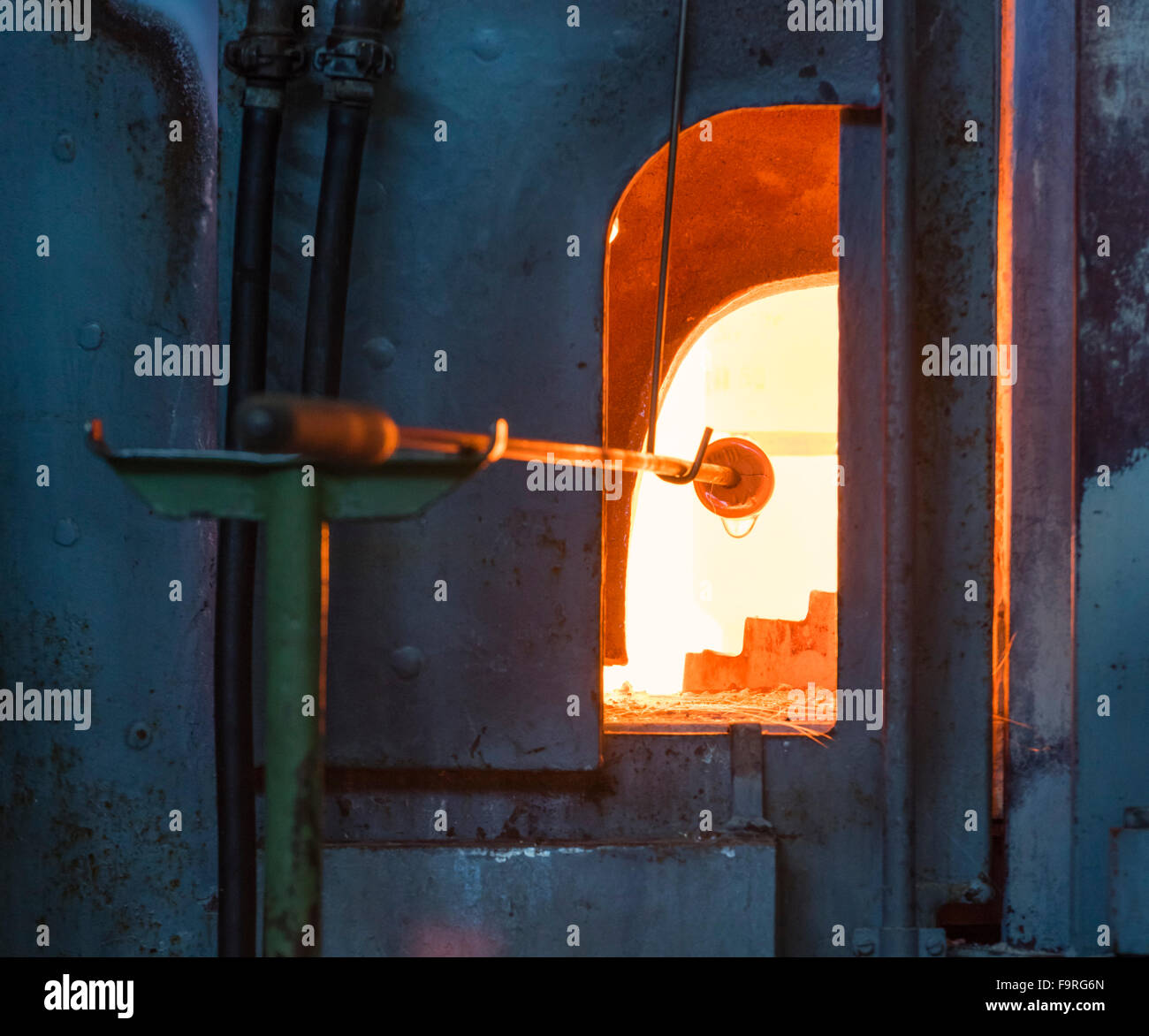 Melted glass, glowing red hot, in the melting furnace of the ...
