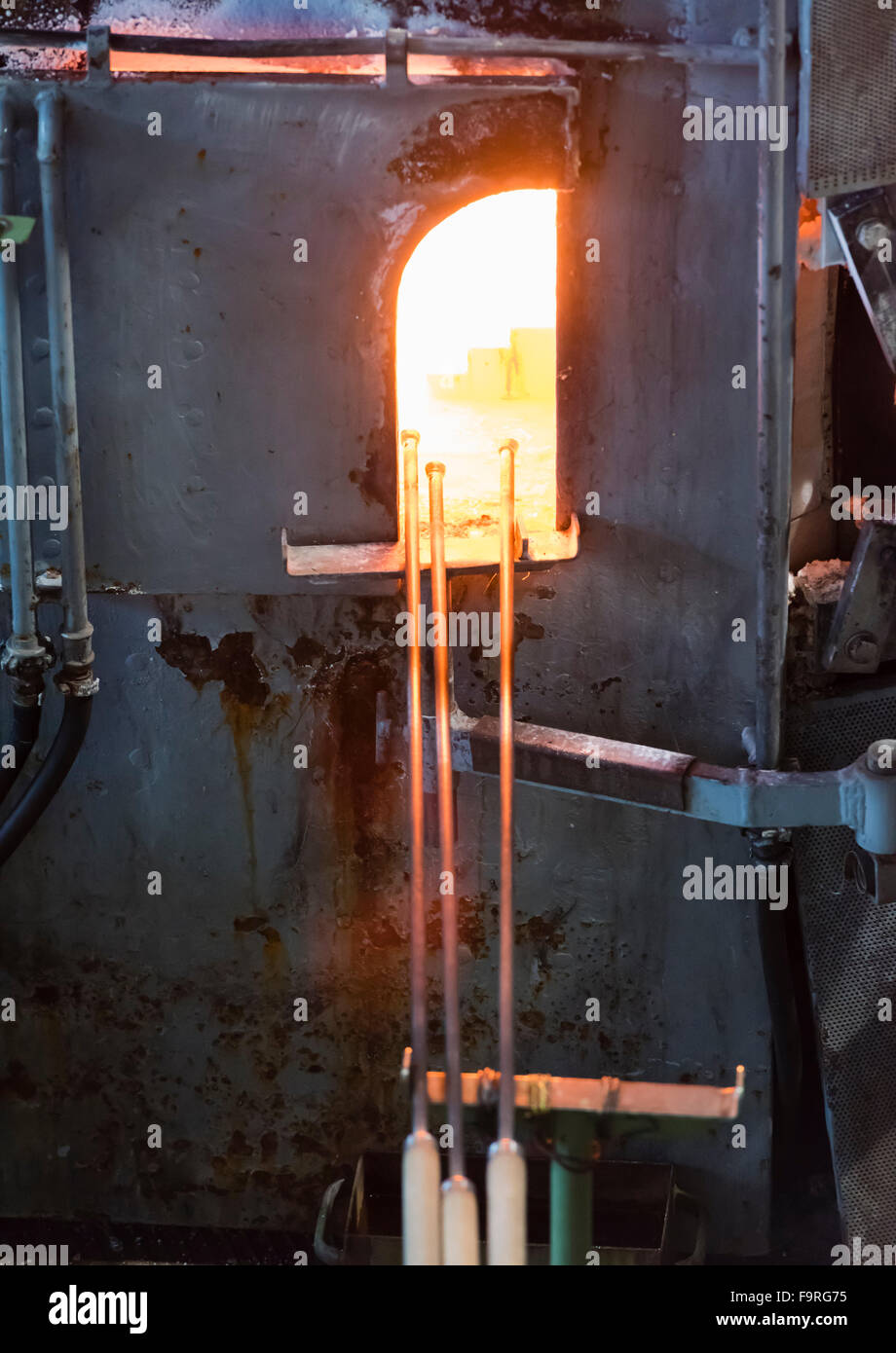 Melted glass, glowing red hot, in the melting furnace of the ...