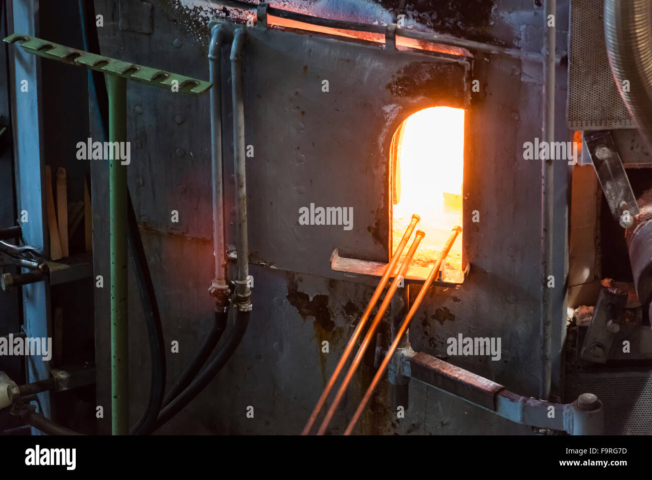 Melted glass, glowing red hot, in the melting furnace of the ...