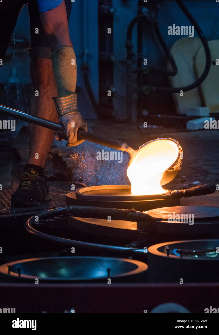 Glassblowers working in front of the furnace at the glass factory ...