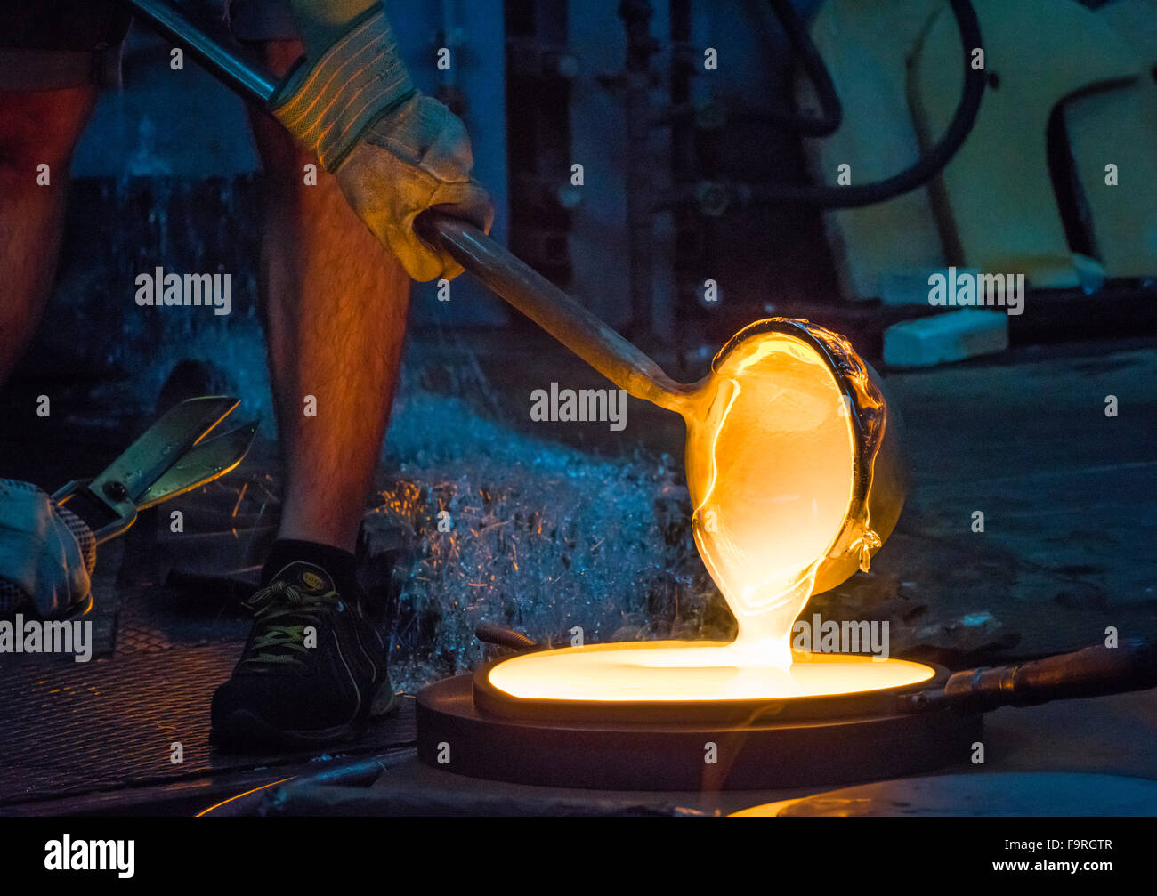 Glassblowers working in front of the furnace at the glass factory ...