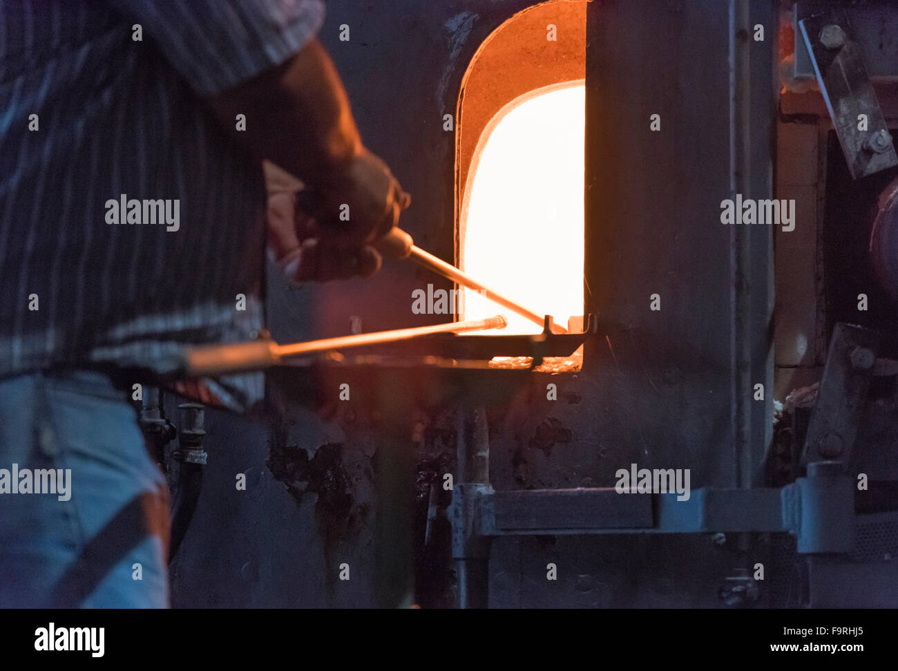 Melted glass, glowing red hot, in the melting furnace of the ...