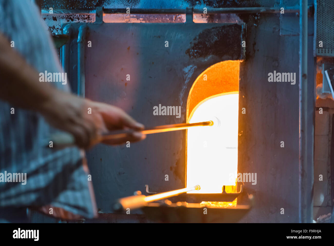 Melted glass, glowing red hot, in the melting furnace of the ...