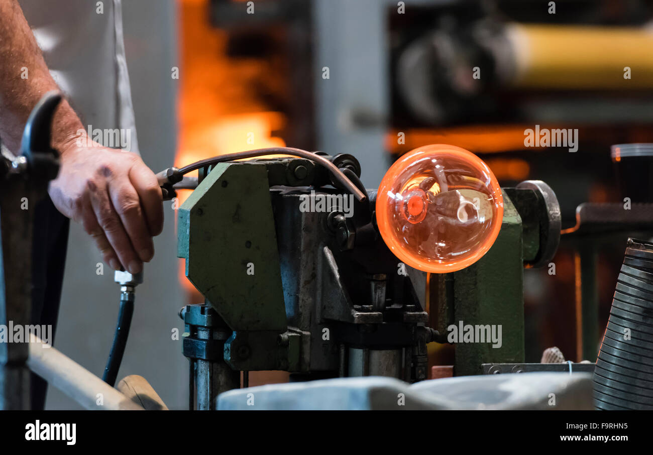 A piece of red hot melted glass is cooling down before further ...