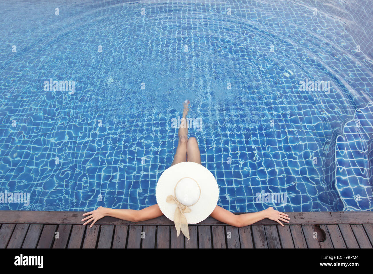 Woman in big hat relaxing in swimming pool Stock Photo - Alamy