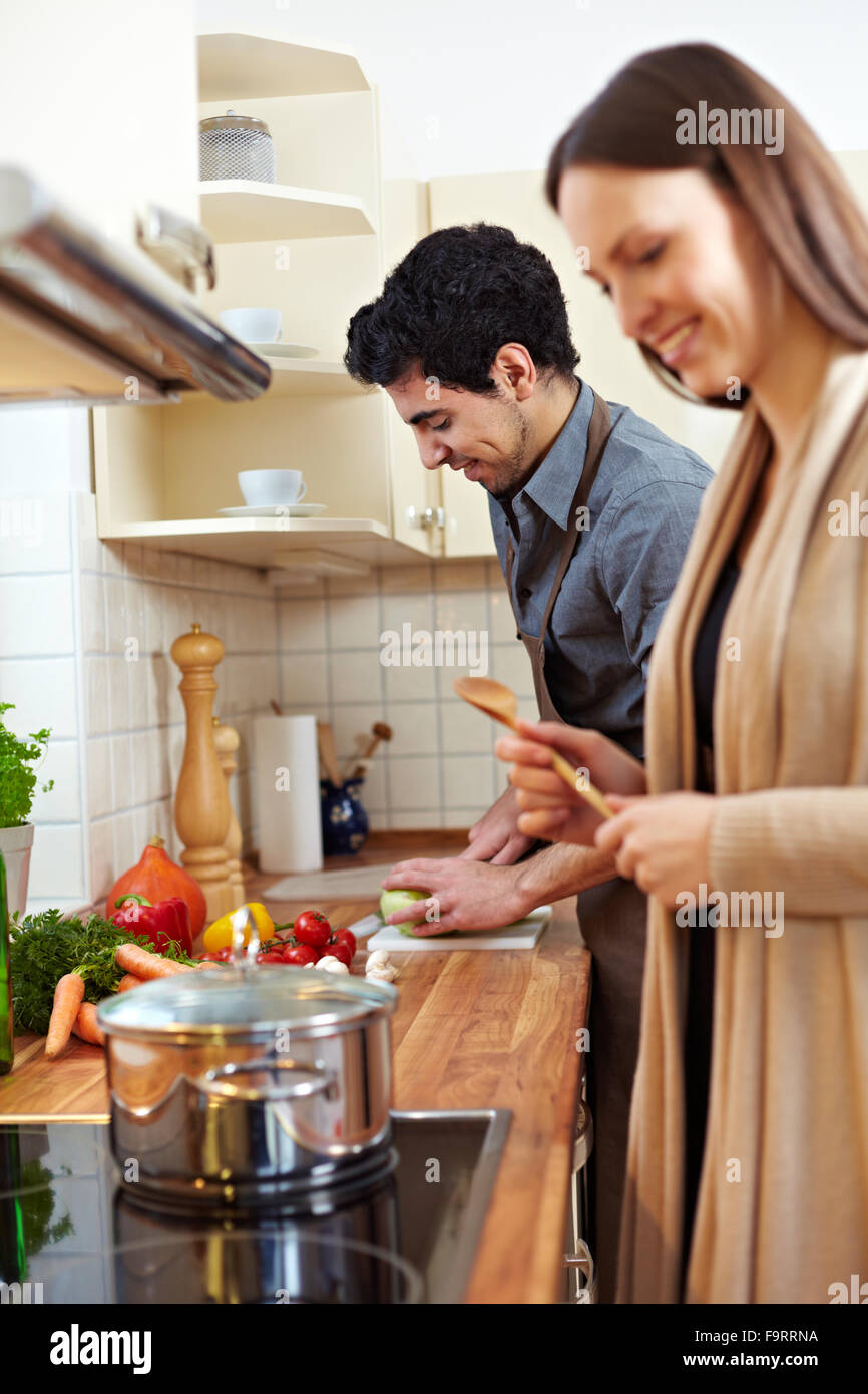 Happy young couple cooking a soup together in the kitchen Stock Photo ...