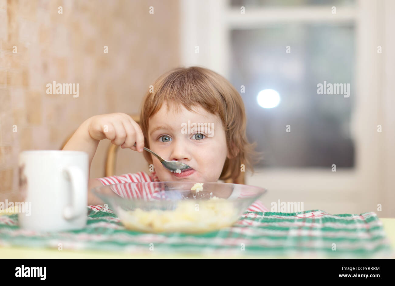 child eats potato with spoon in home Stock Photo - Alamy