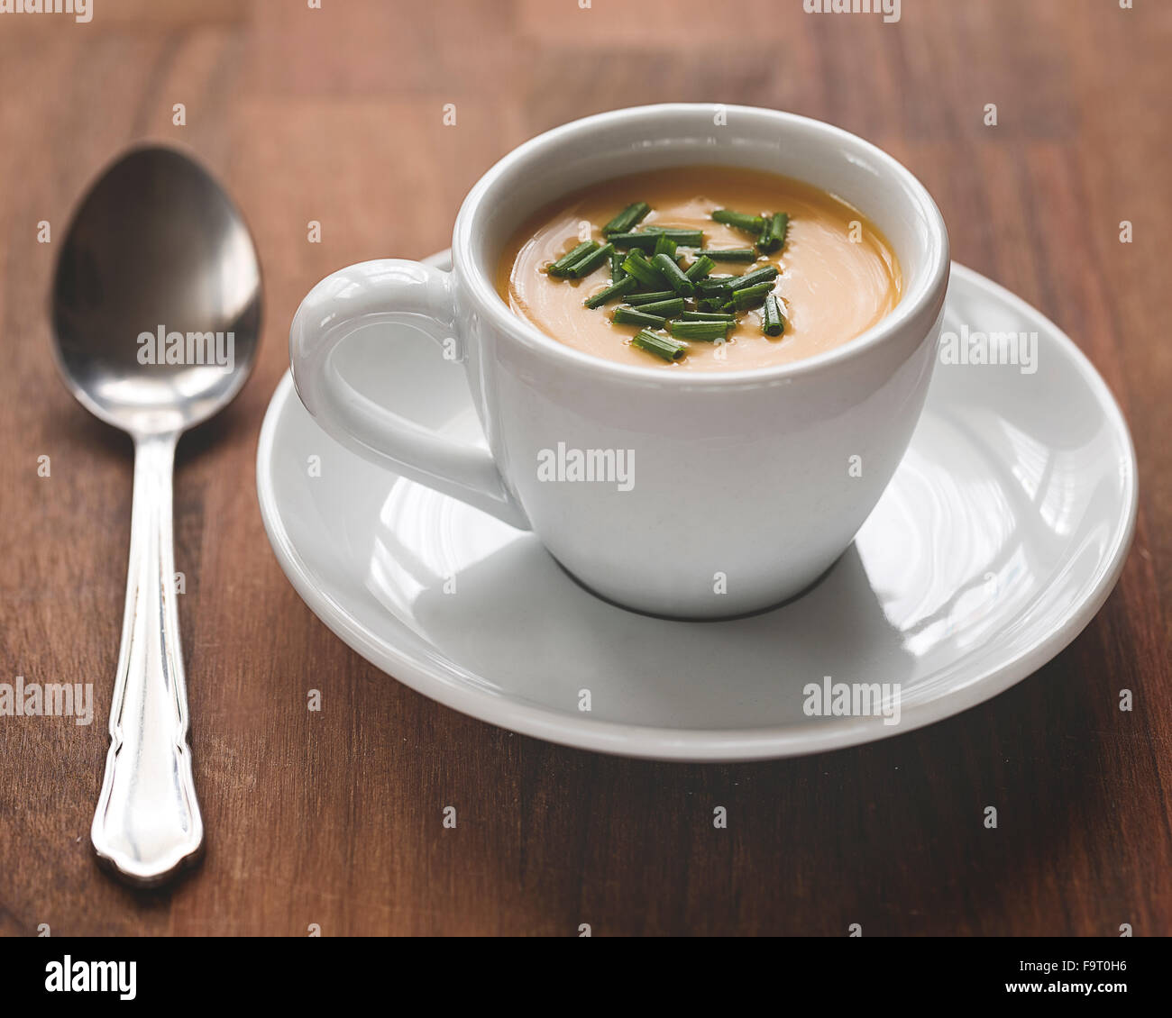 Butternut squash veloute served in a tea cup and saucer garnished with ...