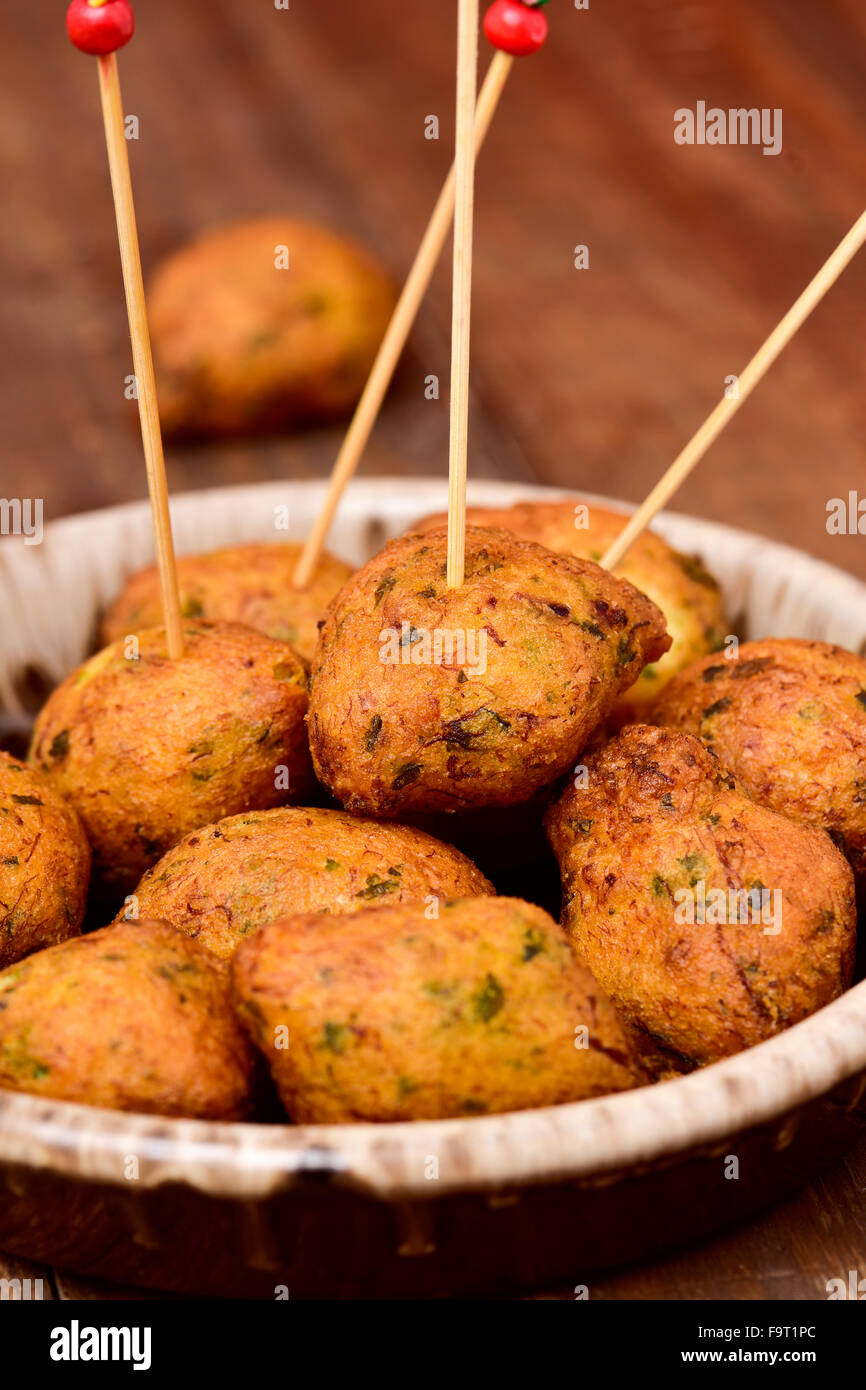 an earthenware plate with some bunuelos de bacalao, spanish cod ...