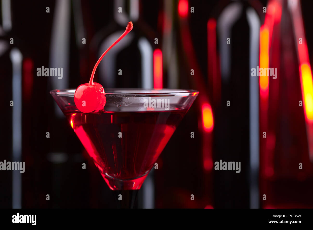 Cocktail with cherry on black table in bar Stock Photo - Alamy