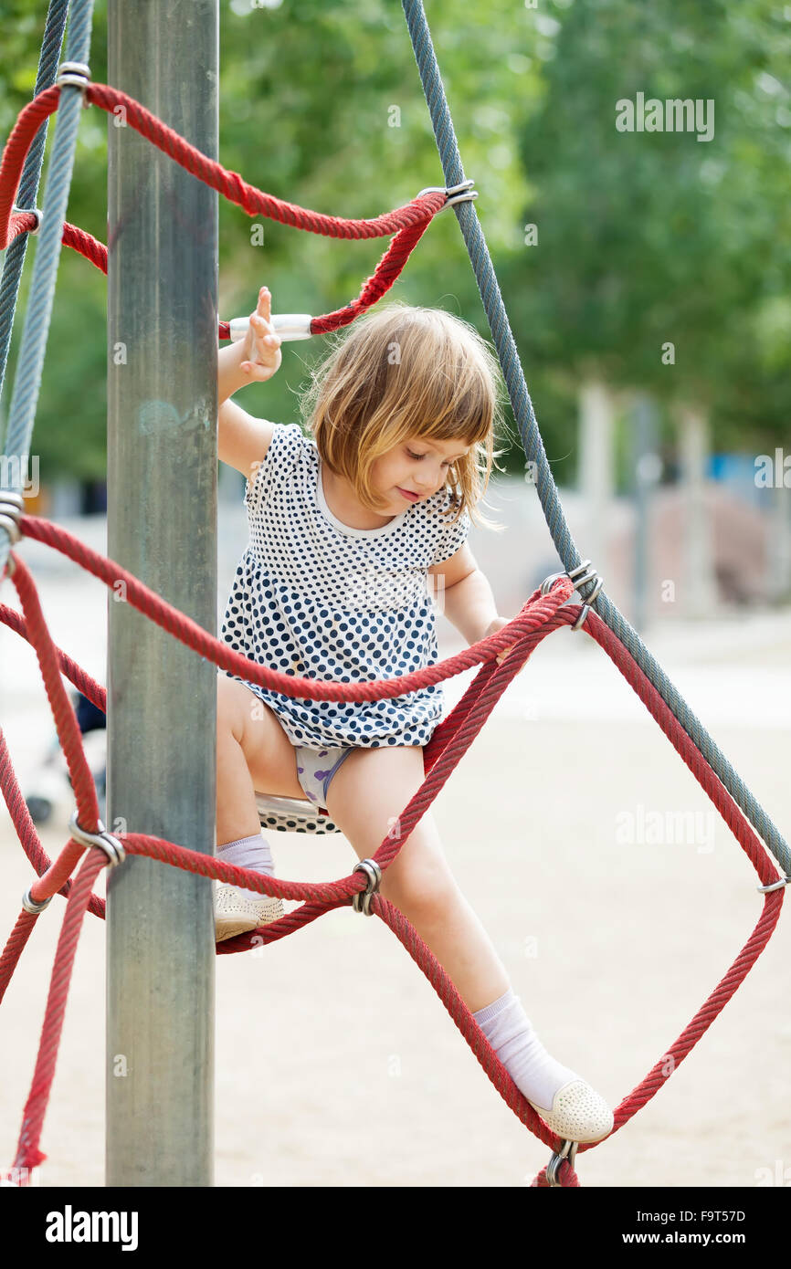 girl in dress climbing on ropes at playground area Stock Photo - Alamy