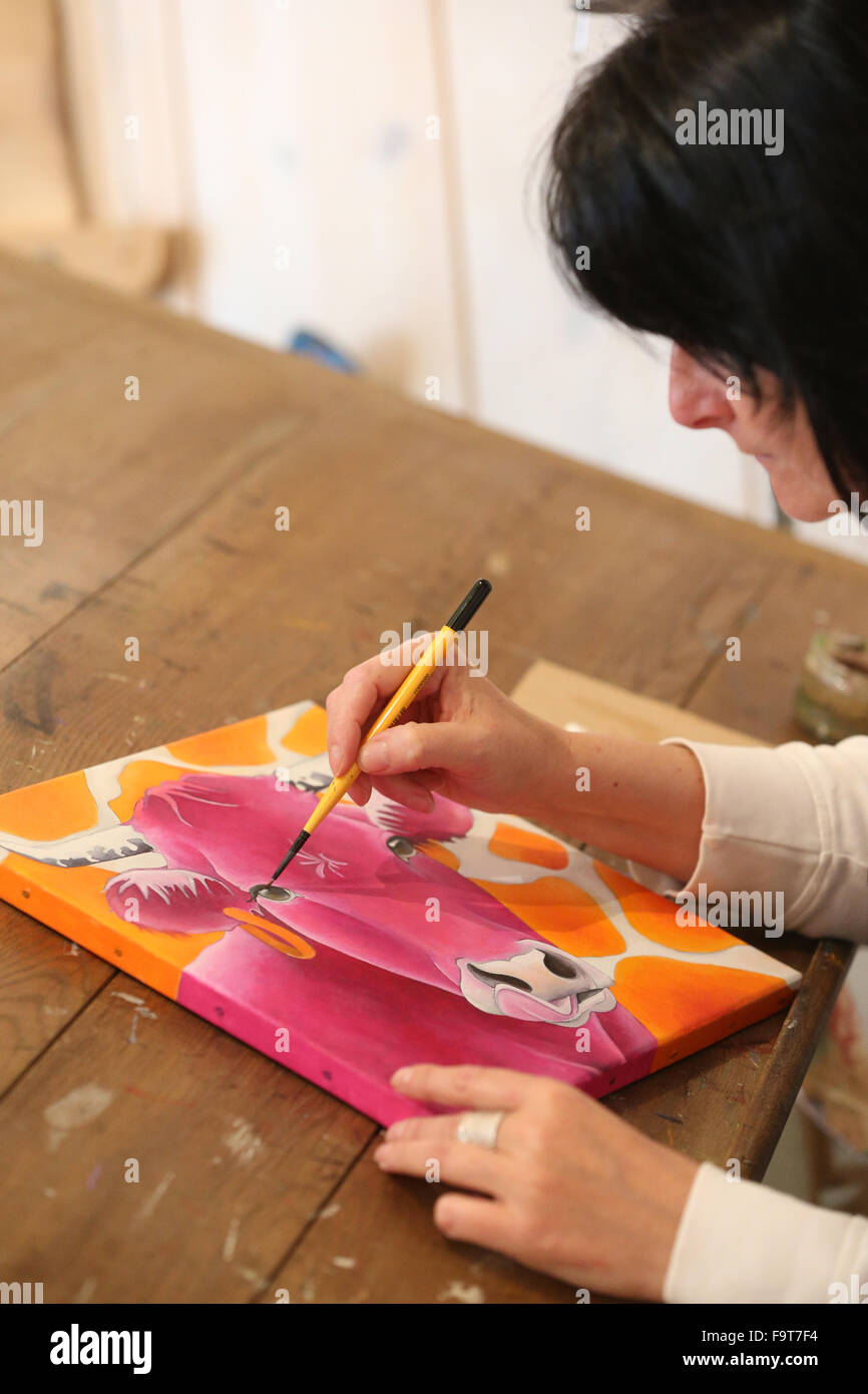 French artist Muriel Mollier Pierret painting in her gallery Stock ...