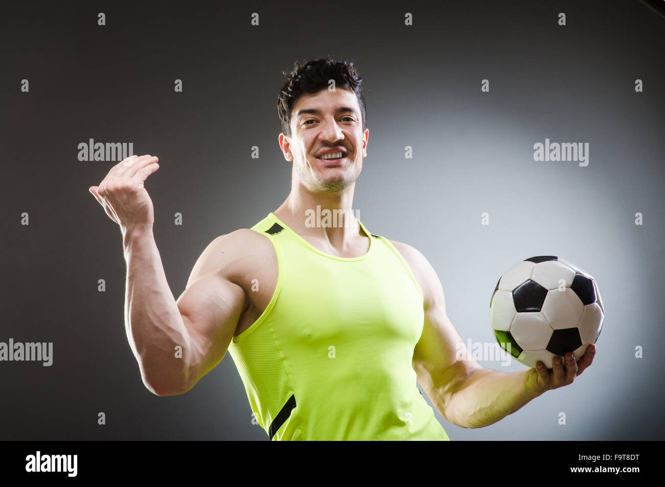 Muscular man with football ball Stock Photo - Alamy