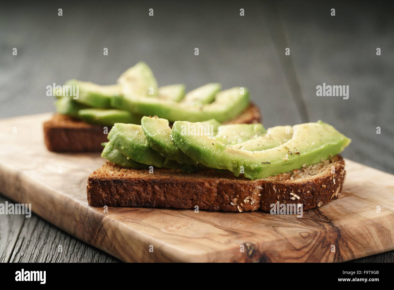 toasted rye bread with sliced avocado and herbs Stock Photo - Alamy