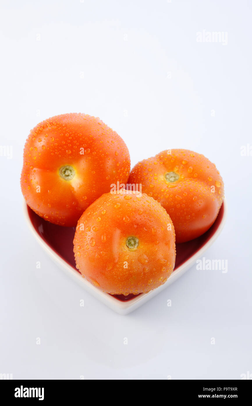 fresh red delicious tomatoes in heart-shape plate Stock Photo - Alamy