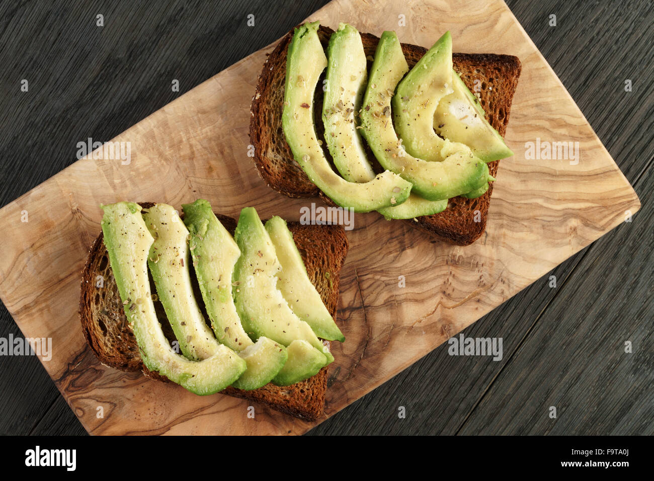 toasted rye bread with sliced avocado and herbs Stock Photo - Alamy