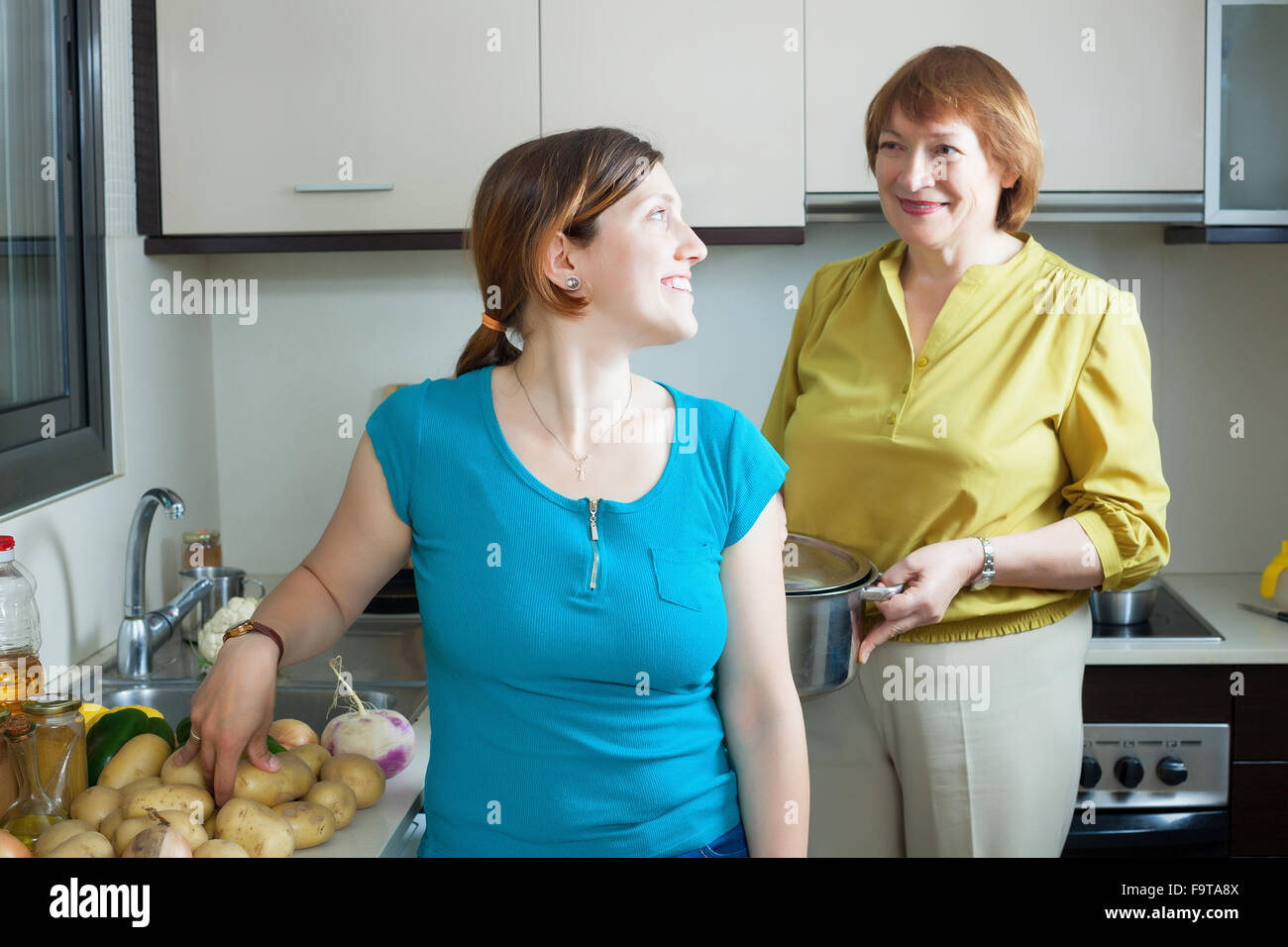 Happy women together cooking in kitchen at home Stock Photo - Alamy