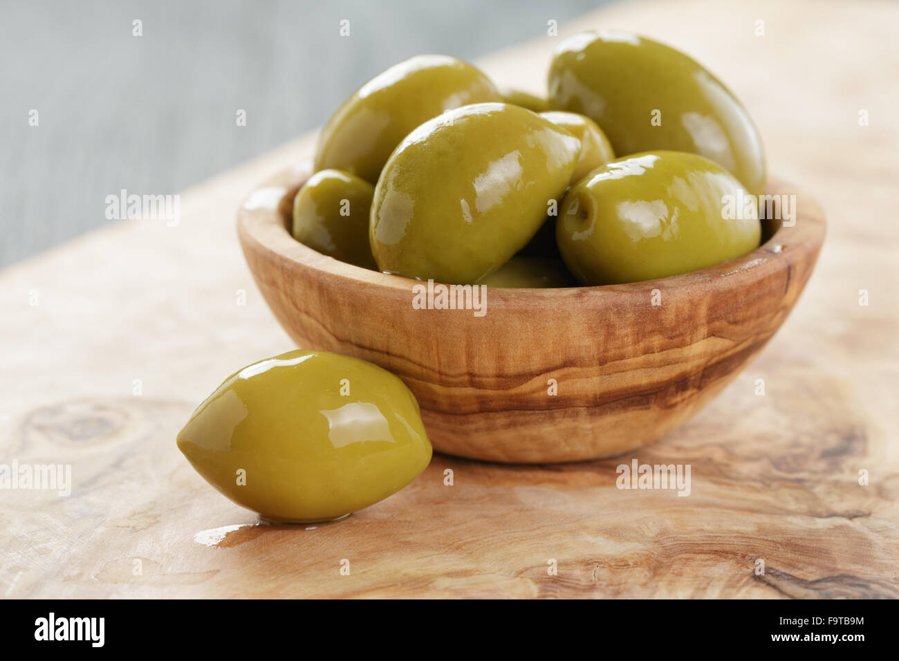 giant green olives in olive bowl on wood background Stock Photo - Alamy