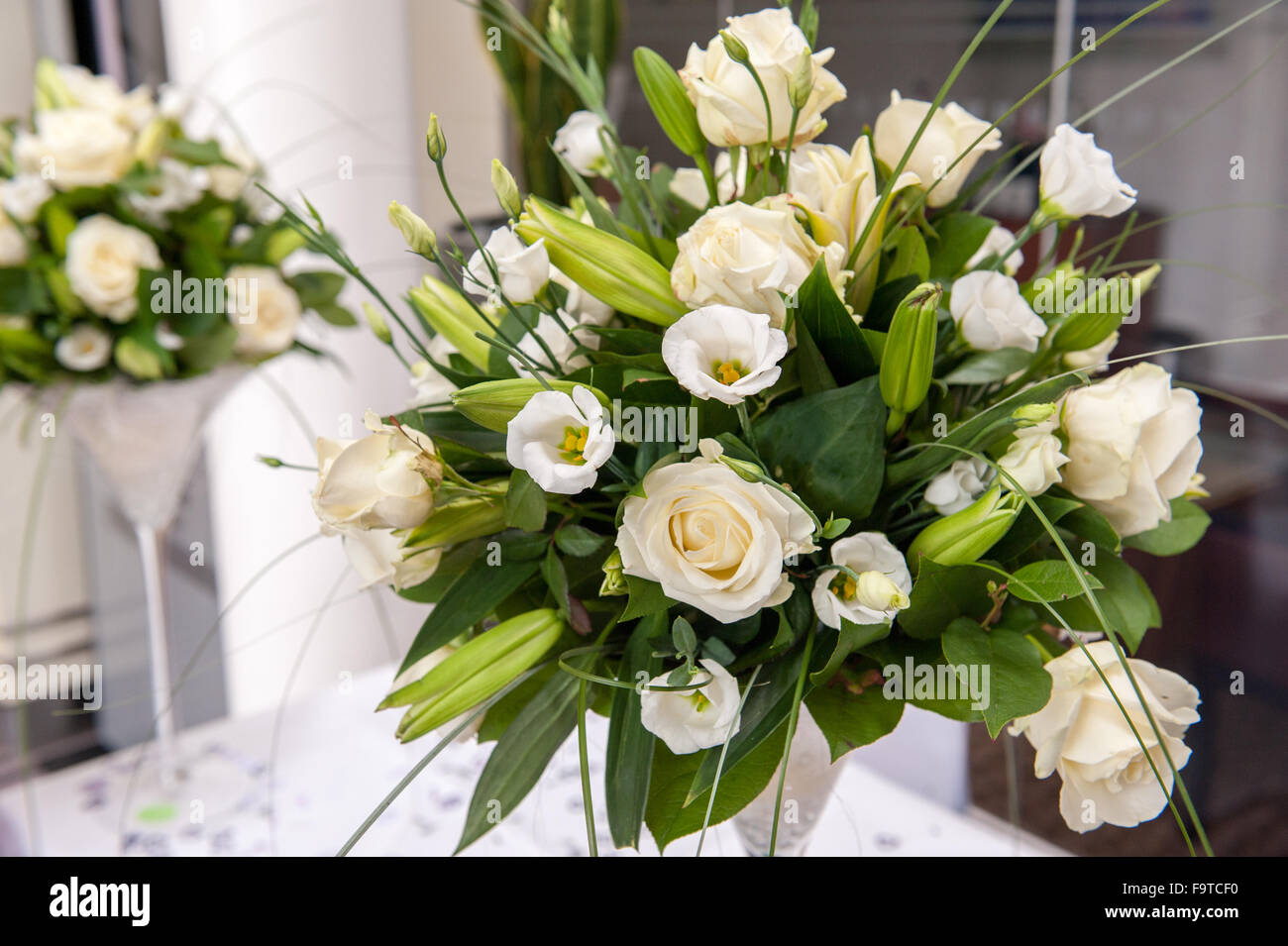 White flower bouquet on display with green leaves Stock Photo - Alamy