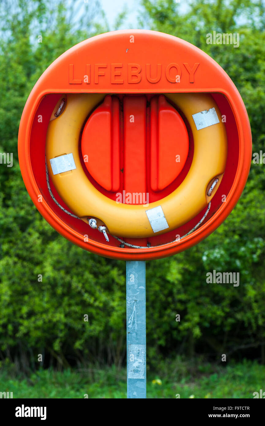Round circular orange life saver at lakeside Stock Photo - Alamy