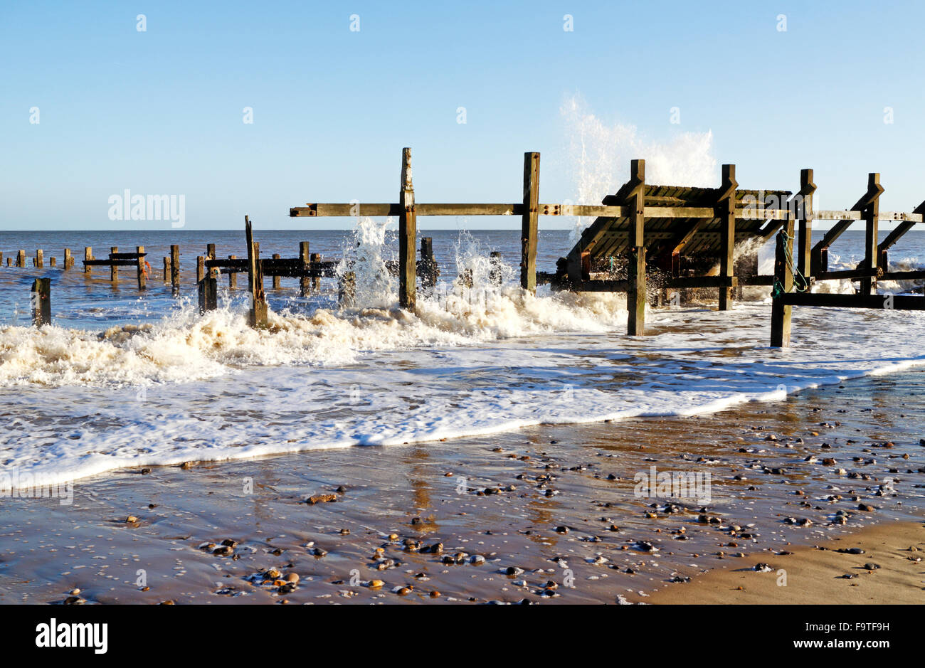 Old wooden coastal sea defences buffeted by waves at Happisburgh ...