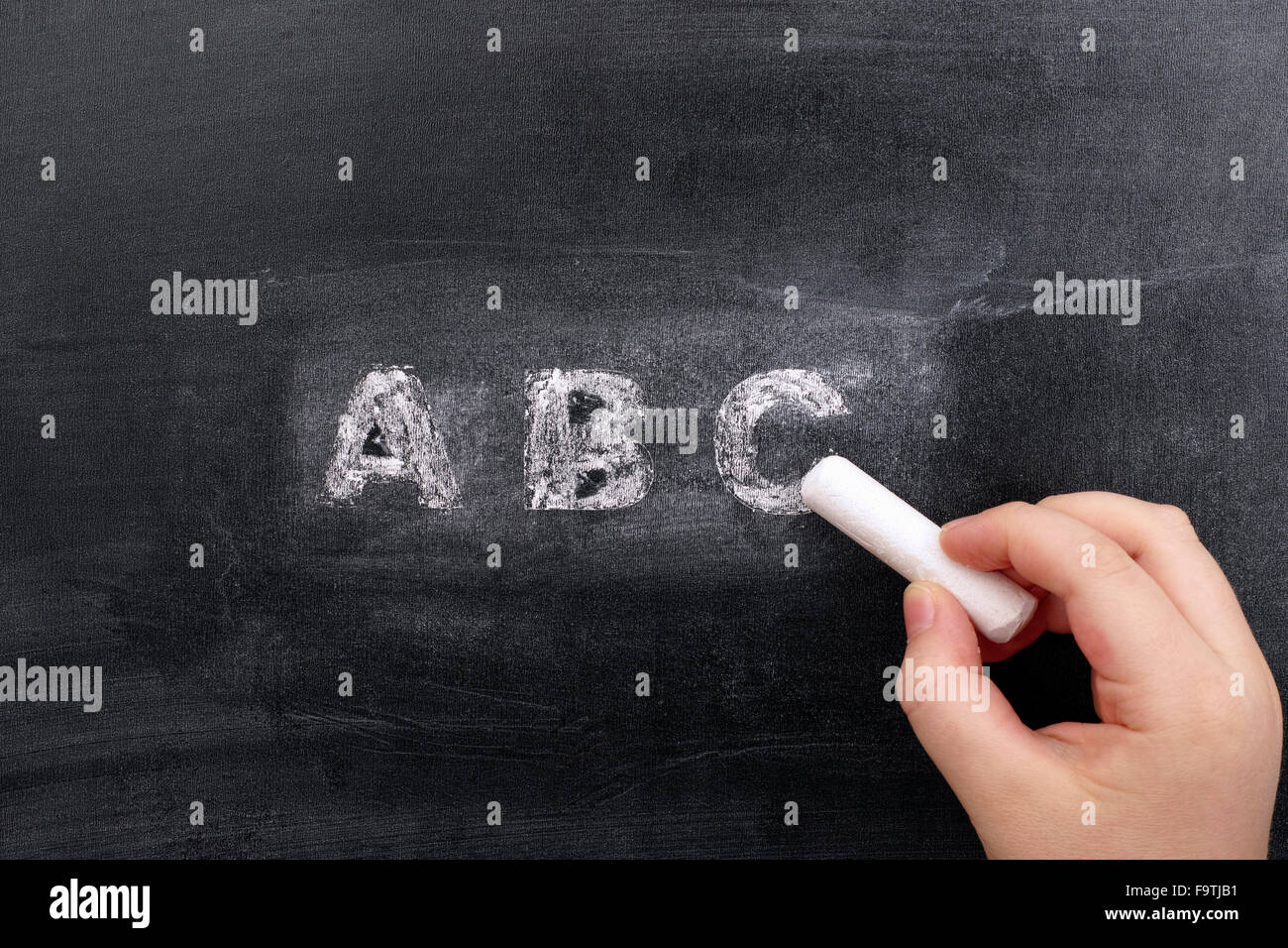 Childs hand writing ABC on blackboard. Closeup Stock Photo - Alamy