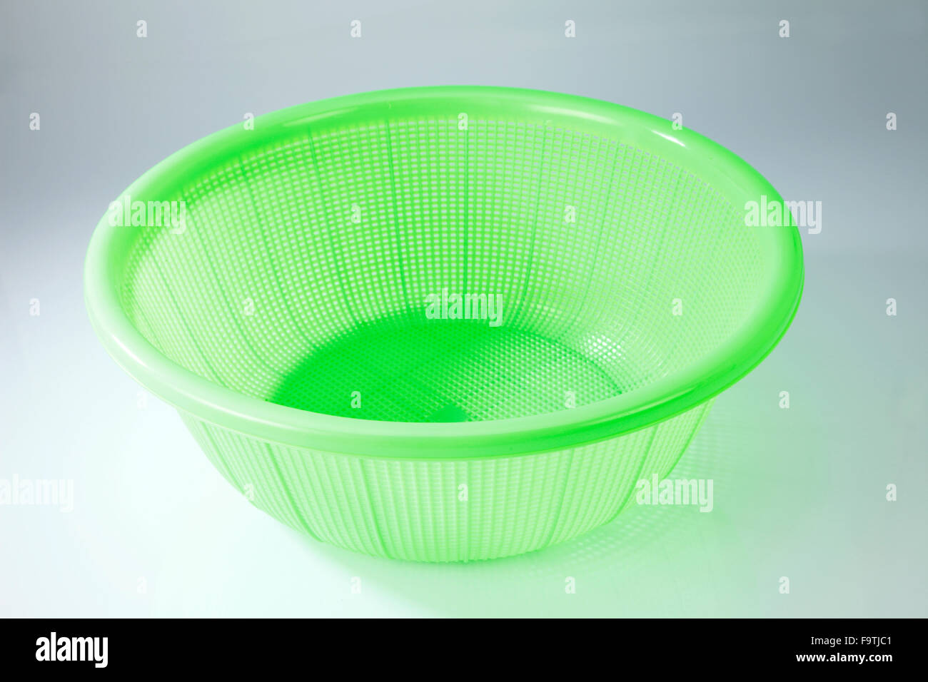 green plastic basket on a white background Stock Photo - Alamy