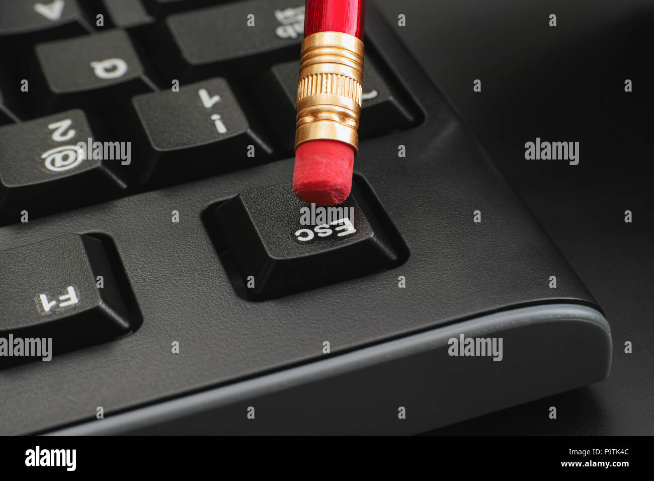 Pencil eraser pressing Esc key on a black keyboard Stock Photo - Alamy