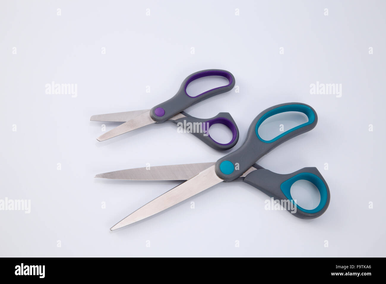 two pair of scissors which one big and small on the white background ...