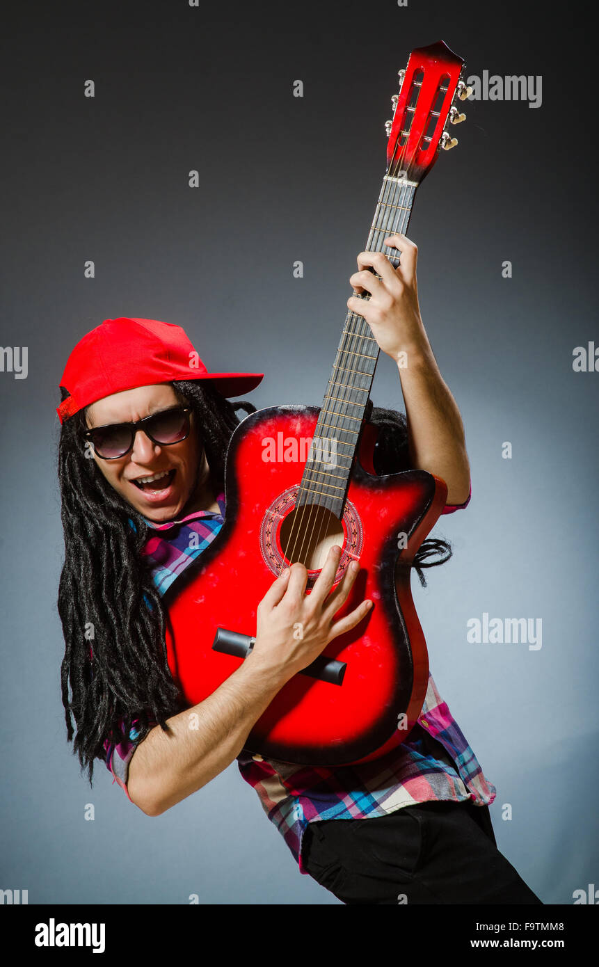 Funny man playing guitar in musical concept Stock Photo - Alamy