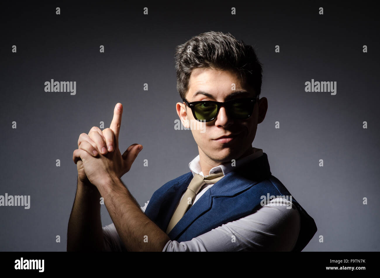 Young man in blue vest against gray Stock Photo - Alamy